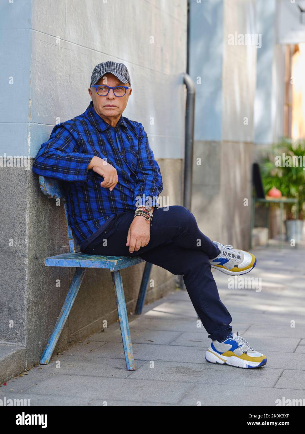 Senior male wearing trendy eyeglasses and blue plaid shirt relaxing on ...