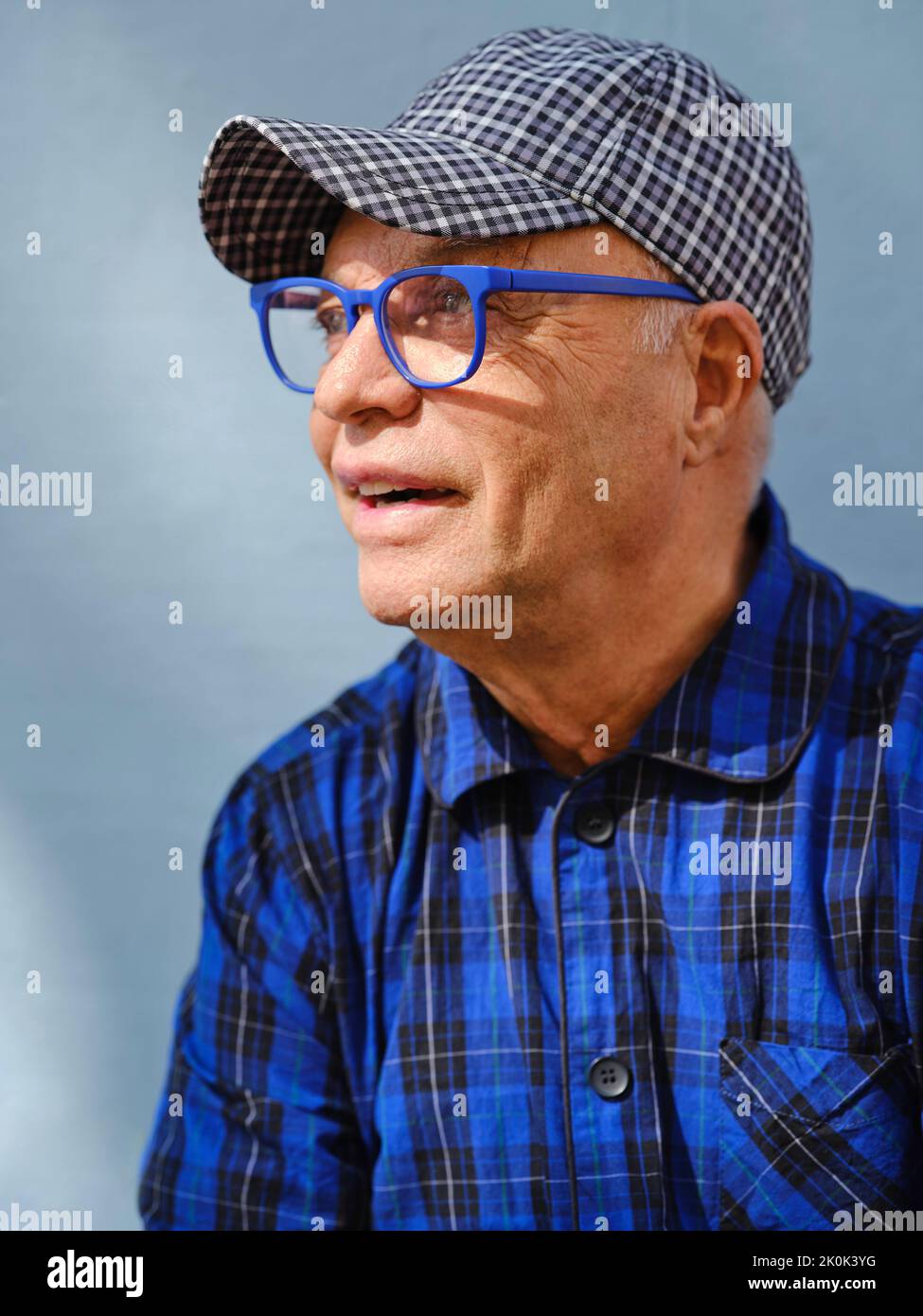 Senior male wearing trendy eyeglasses and blue plaid shirt relaxing on ...