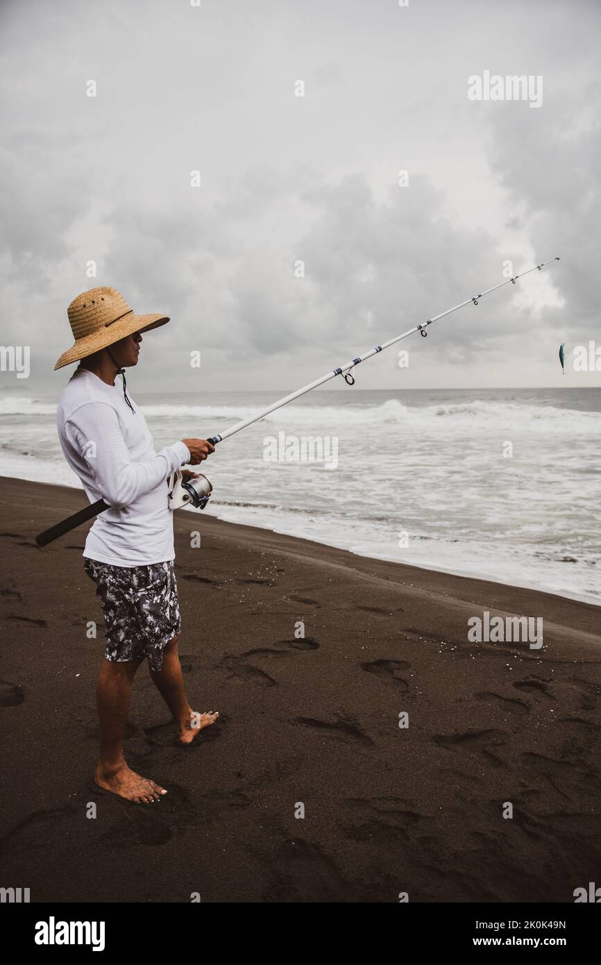 Full body side view of unrecognizable male in hat with fishing rod ...