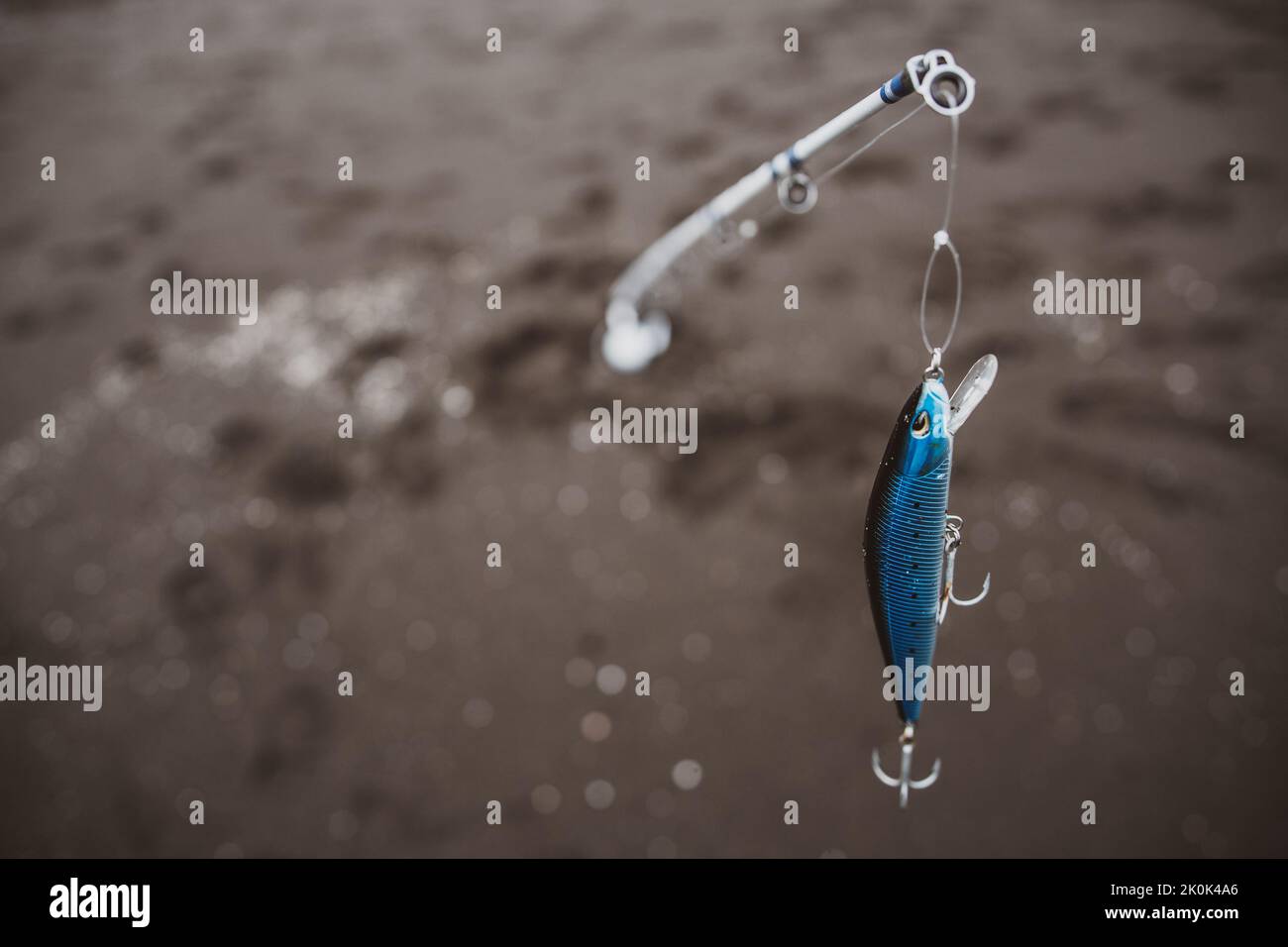 From above of long fishing pole with blue plug and guide rings hanging ...