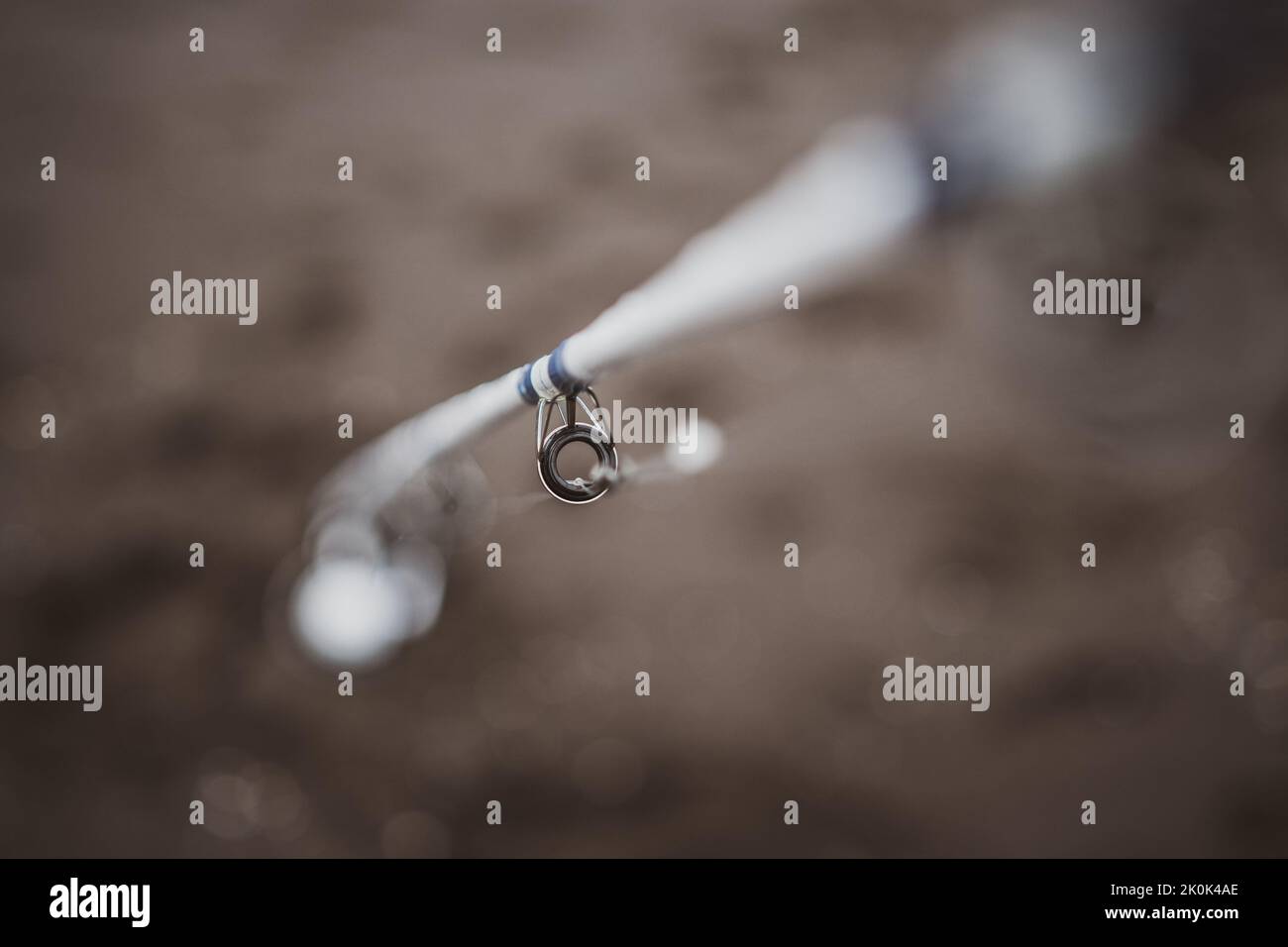 Soft focus from above of guide ring on long fishing pole with line ...