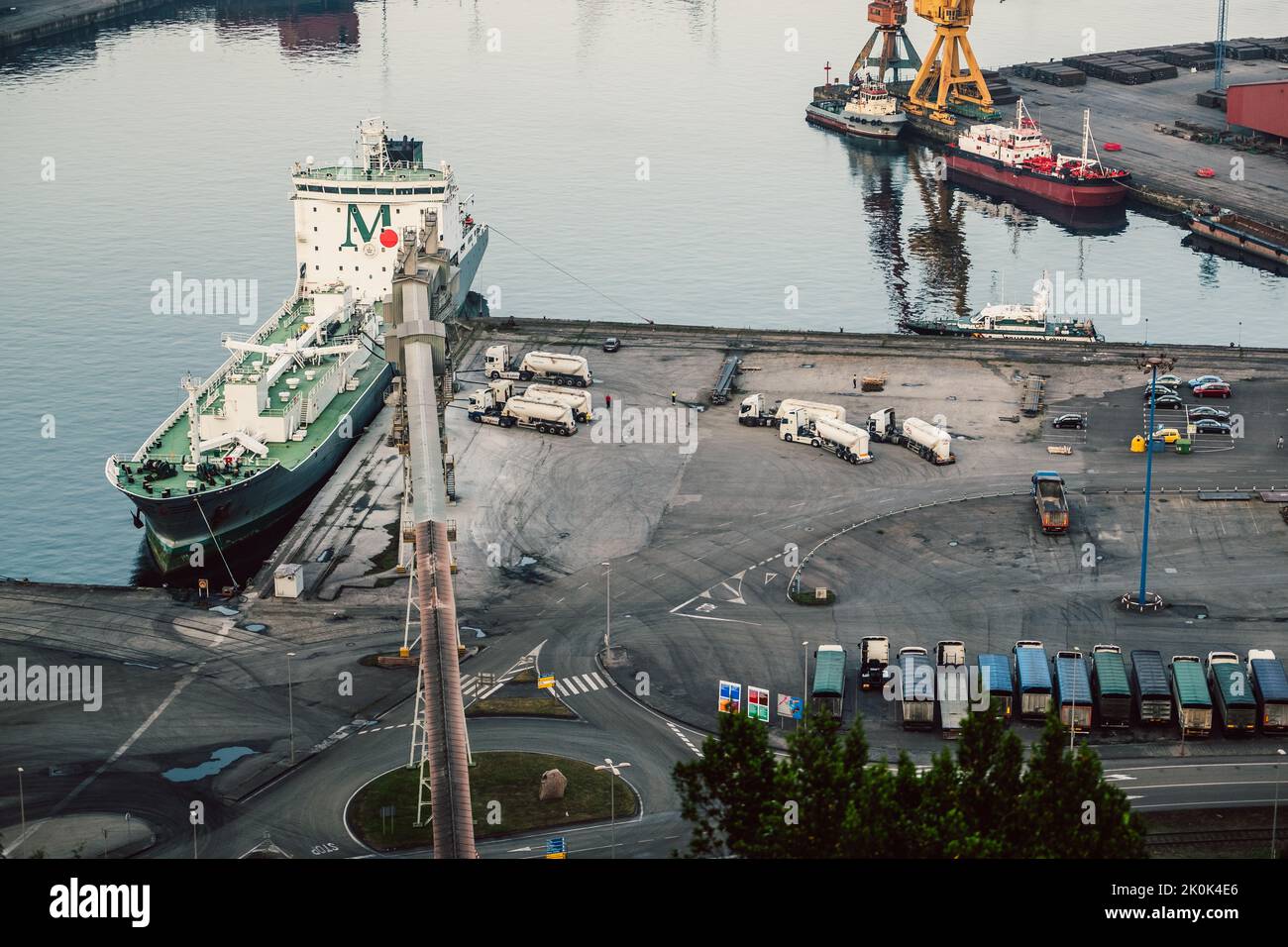 Aerial view of cargo boat with helipad moored at concrete pier on ...