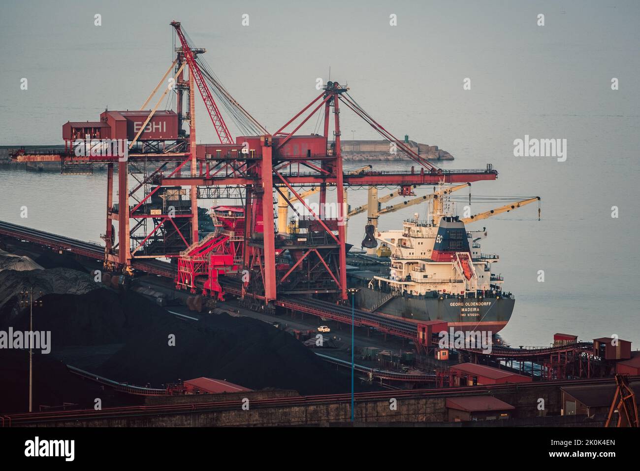 Aerial view of cargo boat with helipad moored at concrete pier on ...