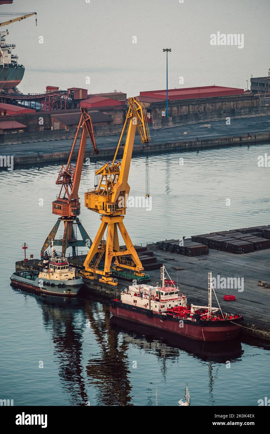 Aerial view of cargo boat with helipad moored at concrete pier on ...
