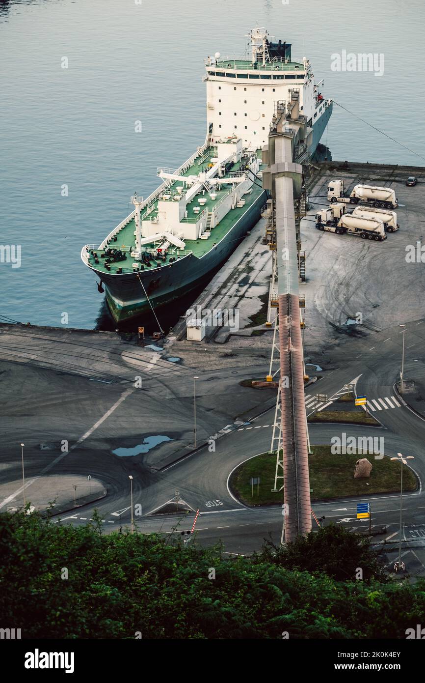 Aerial view of cargo boat with helipad moored at concrete pier on ...
