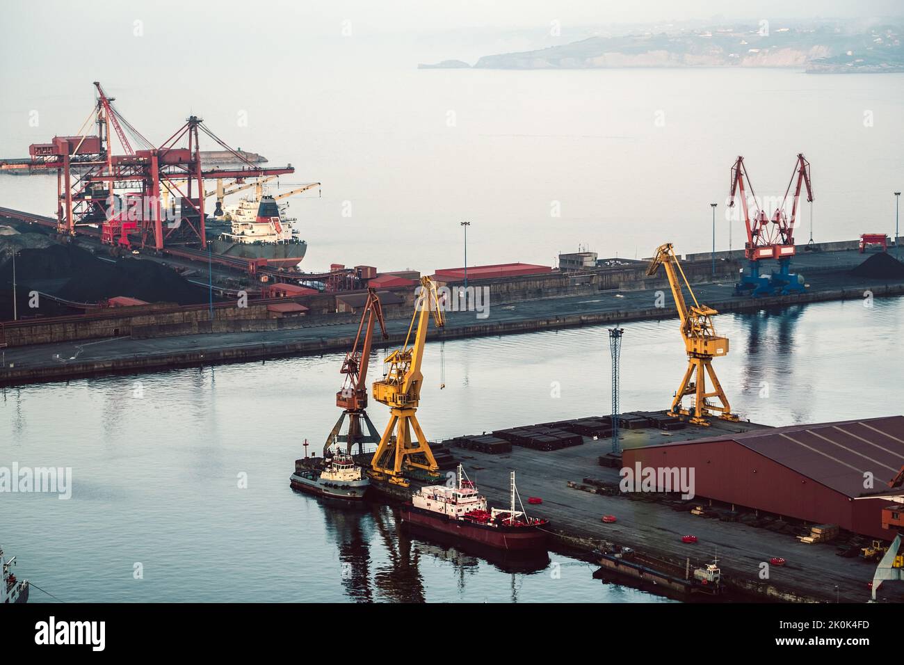 Aerial view of industrial loading harbour with working cranes and ...