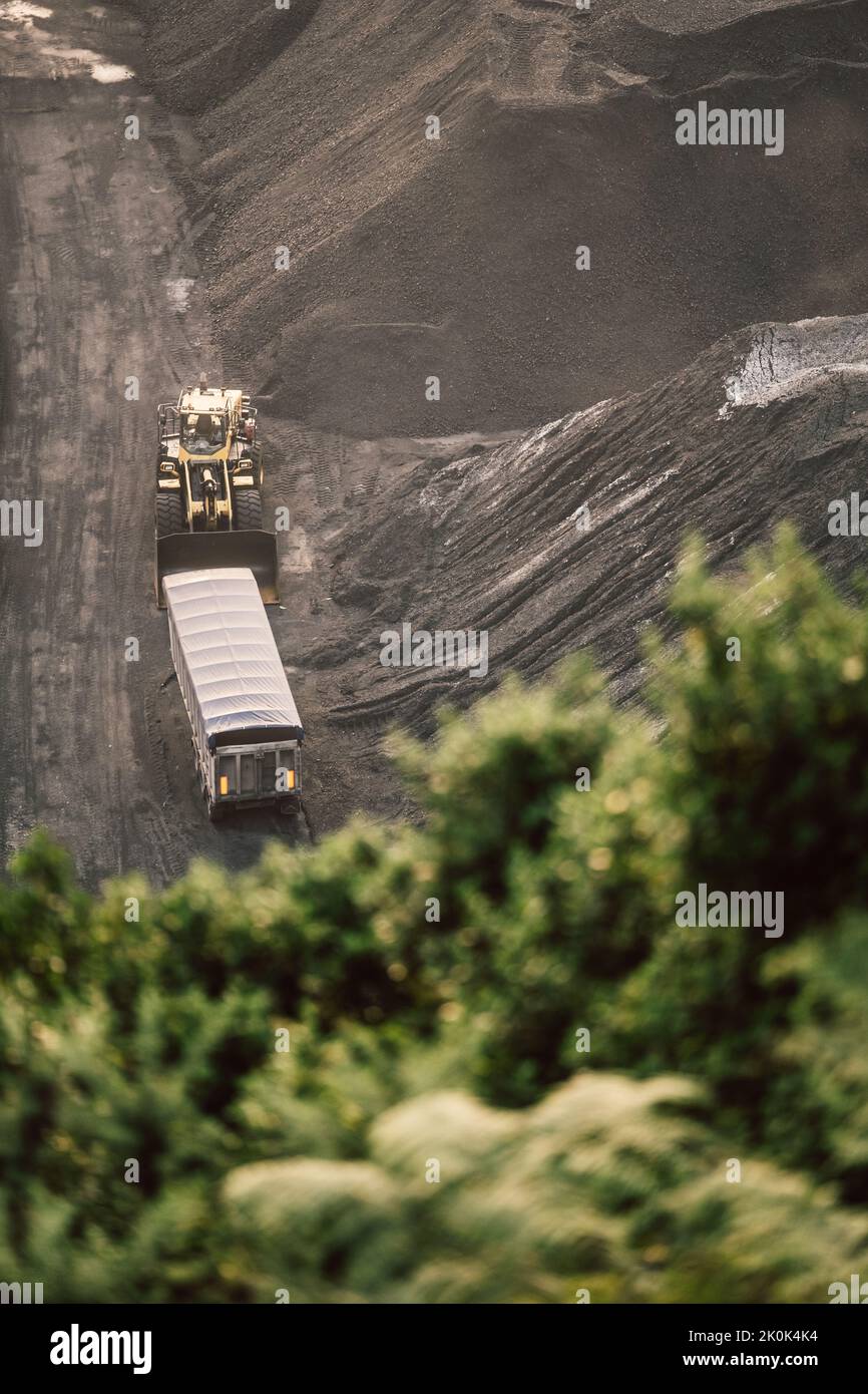 Aerial view of modern loader transporting cargo along coal mining stock ...