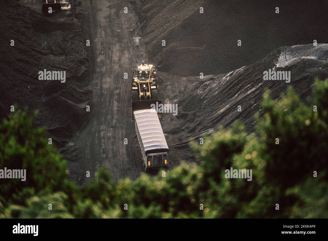 Aerial view of modern loader transporting cargo along coal mining stock ...
