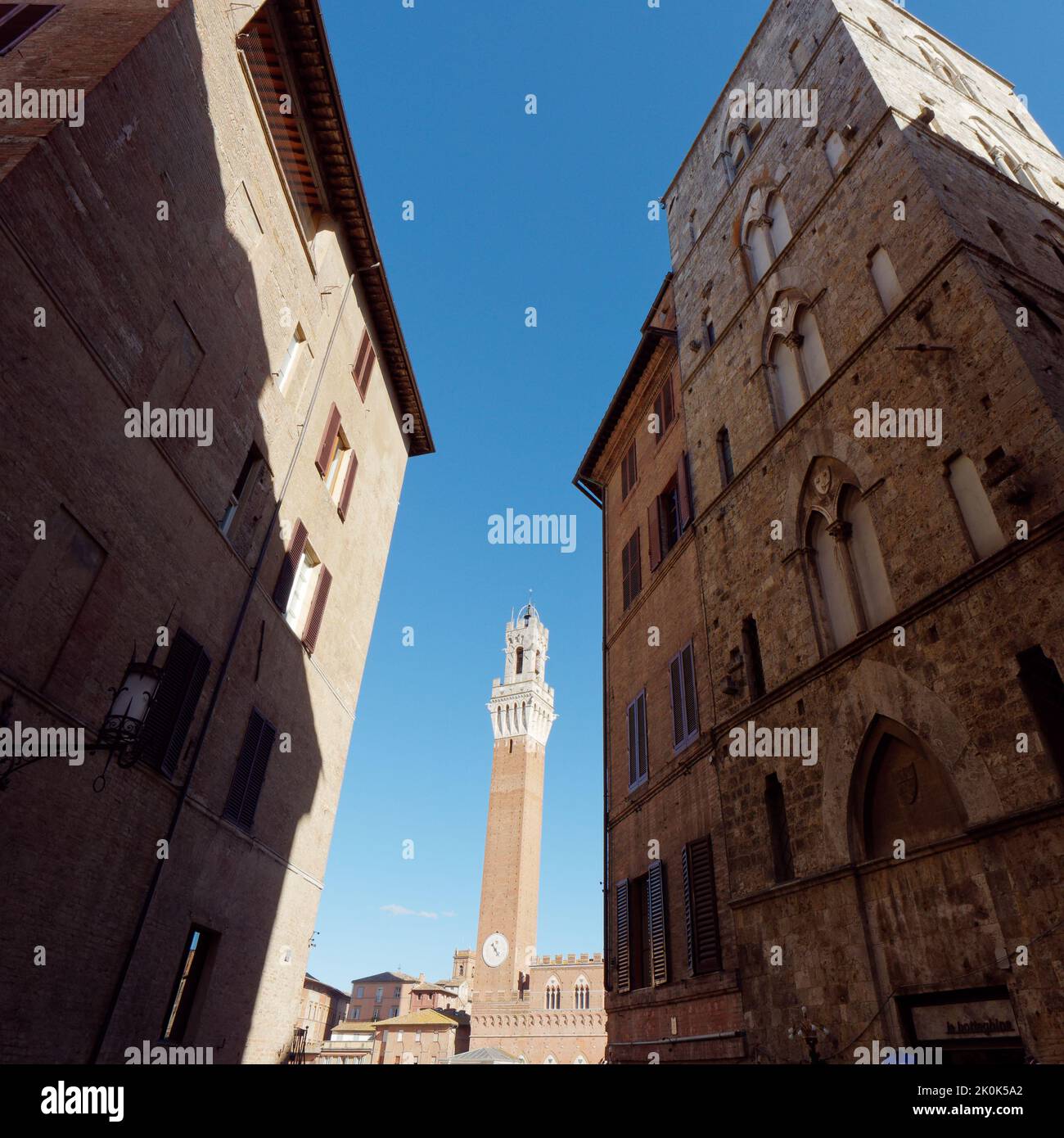 Looking through to the tower in Piazza del Campo, a famous medieval ...