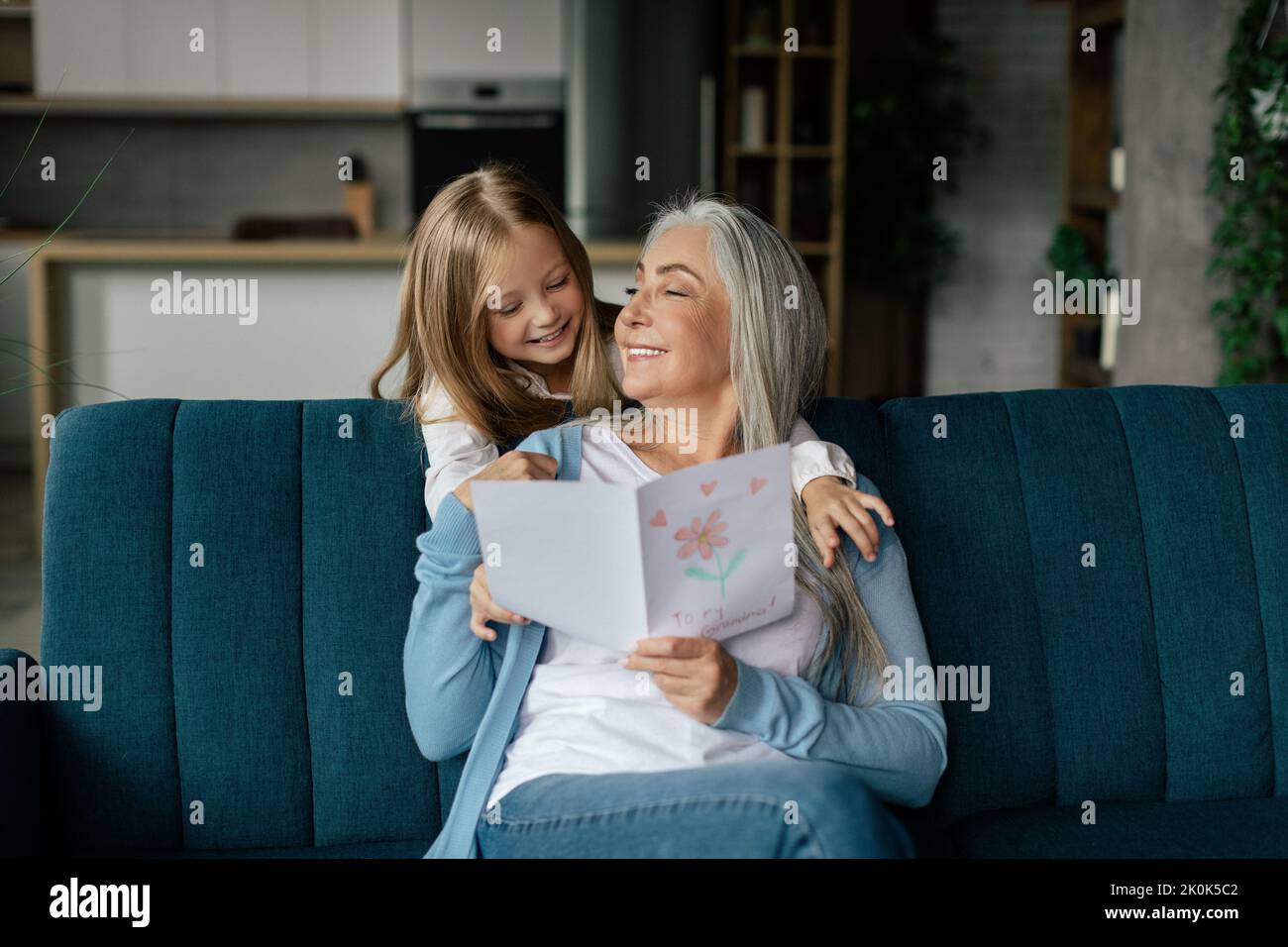 Glad pretty caucasian small granddaughter hugs retired grandmother ...