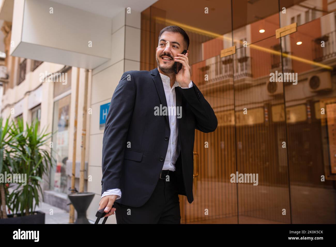 Side view of serious male entrepreneur in formal wear having phone ...