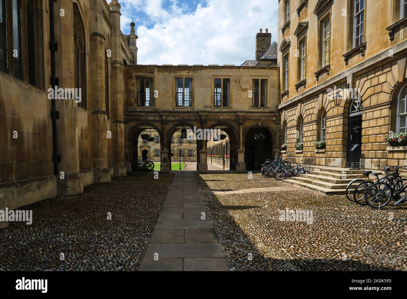 A delicate stone arch passageway with parked bicycles at Peter House ...