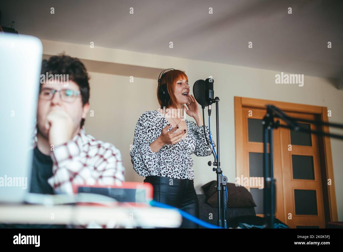 Female singer performing song into professional mic with pop filter ...