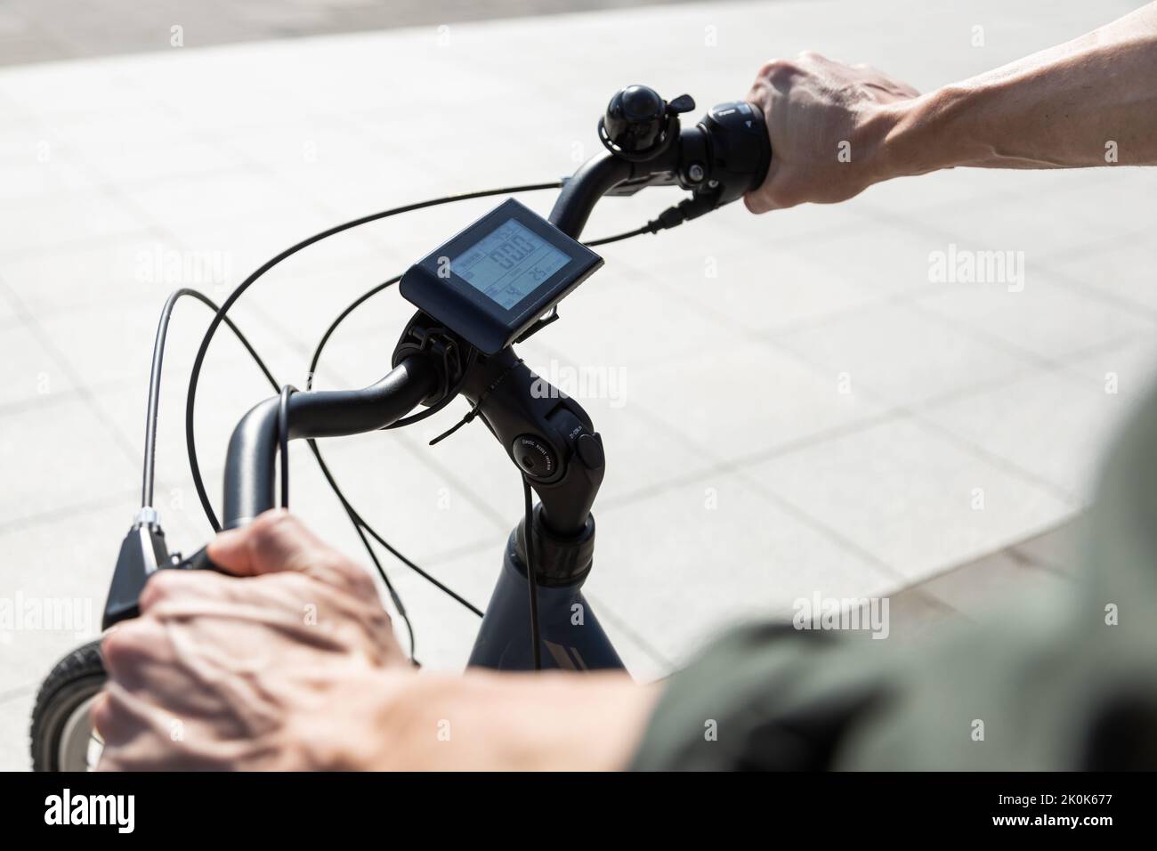 Unrecognizable crop male riding modern electric bicycle with computer ...