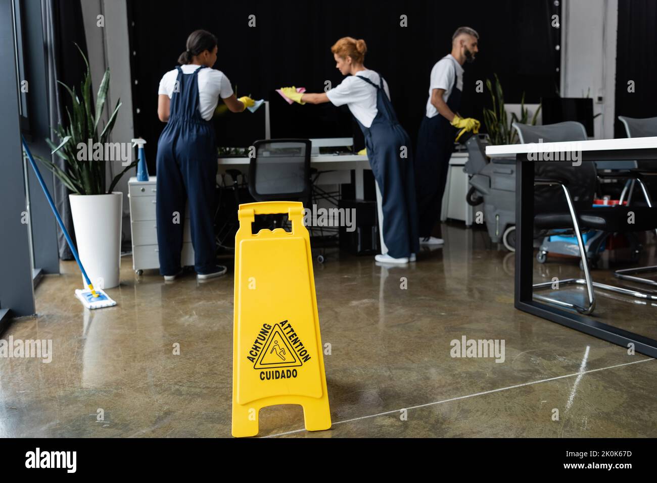 attention sign board near multiethnic professional team cleaning modern ...