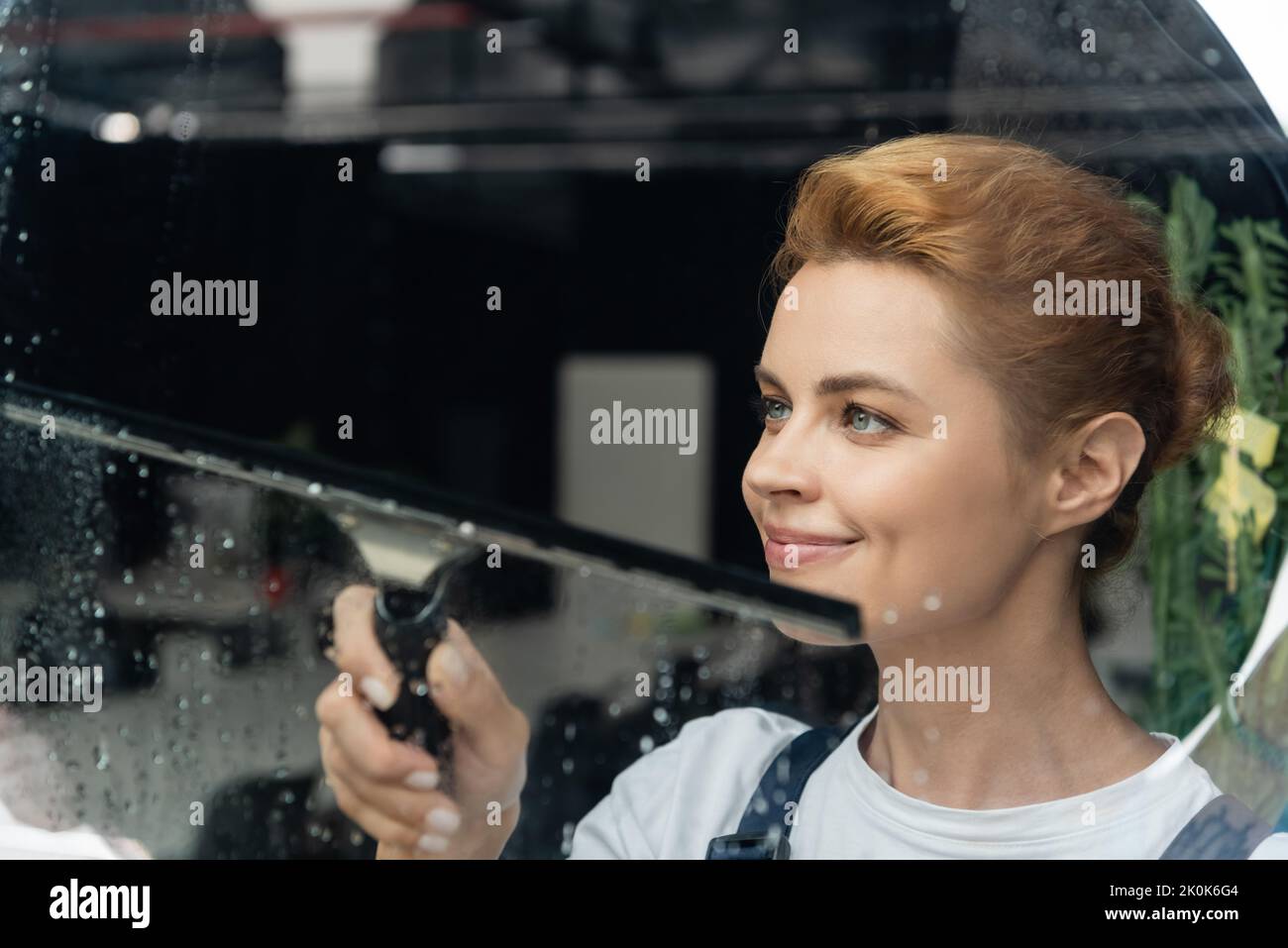 happy professional cleaner smiling near wet window in office,stock ...