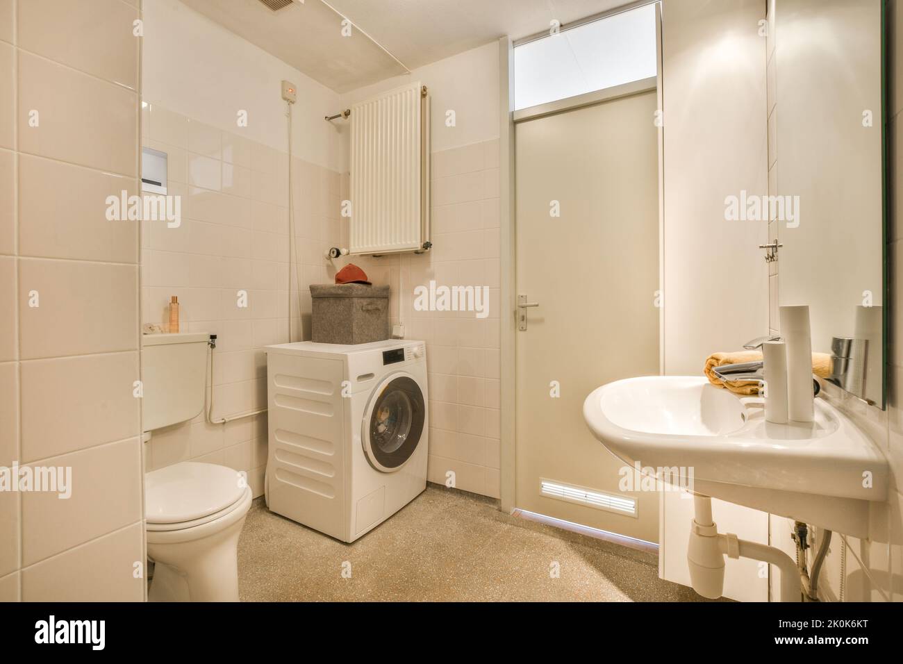 Flush toilet and shower cabin located near sink and washer machine in ...