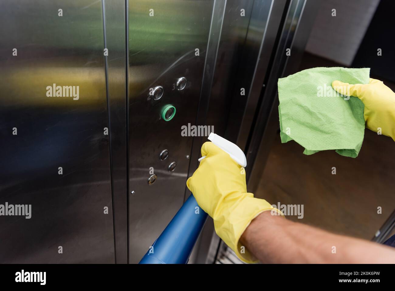 high angle view of cropped cleaner washing elevator with rag and ...