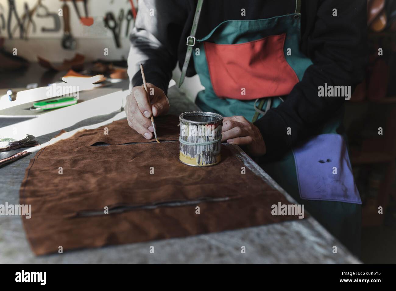 Man varnishing leather in darkness Stock Photo - Alamy