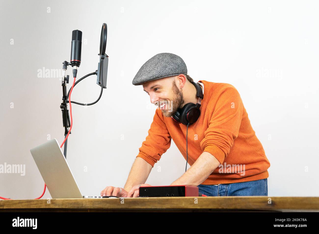 Concentrated happy male worker surfing on laptop with headphones on the ...