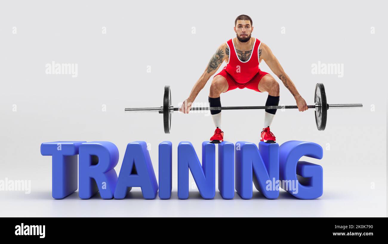 Young muscular athlete with barbell training over huge 3d lettering on ...