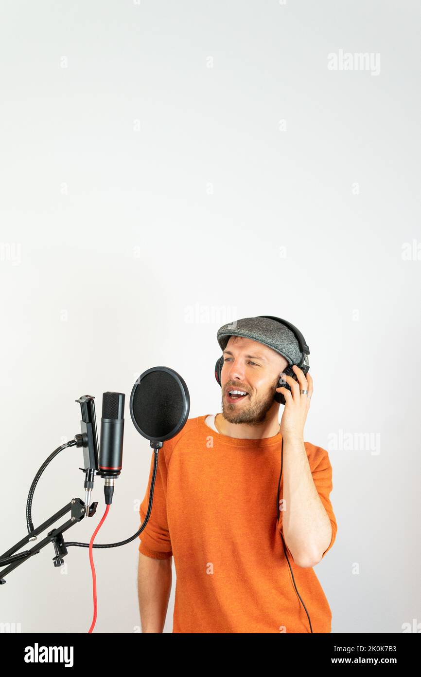 Skilled male singer in casual wear with headphones recording song in ...