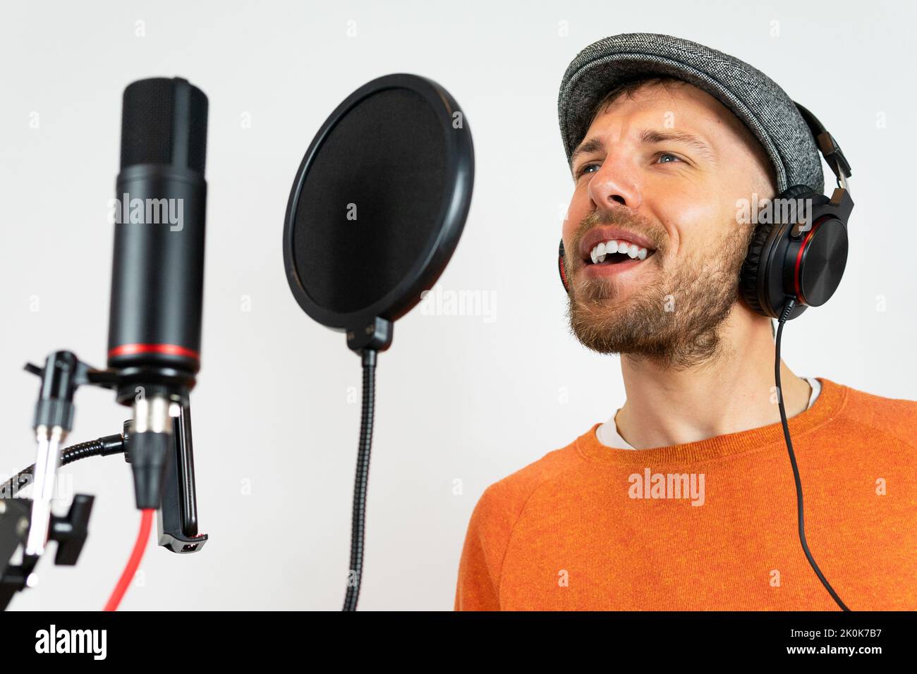 Skilled male singer in casual wear with headphones recording song in ...