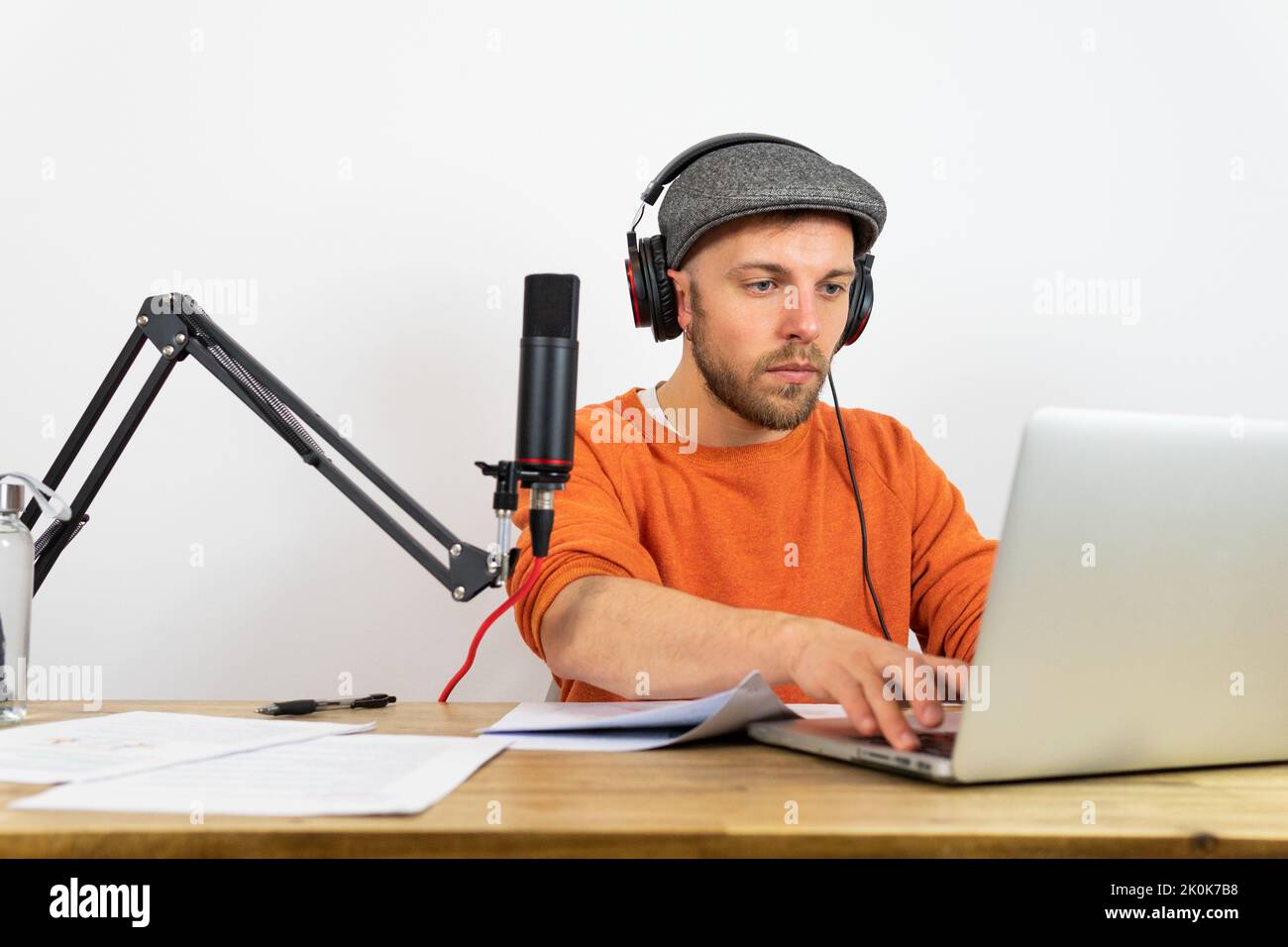 Concentrated male worker with headphones listening to audio while ...
