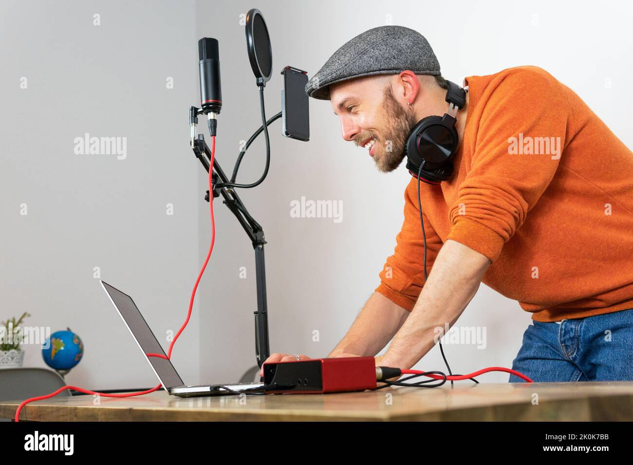 Side view of concentrated male worker surfing on laptop with headphones ...