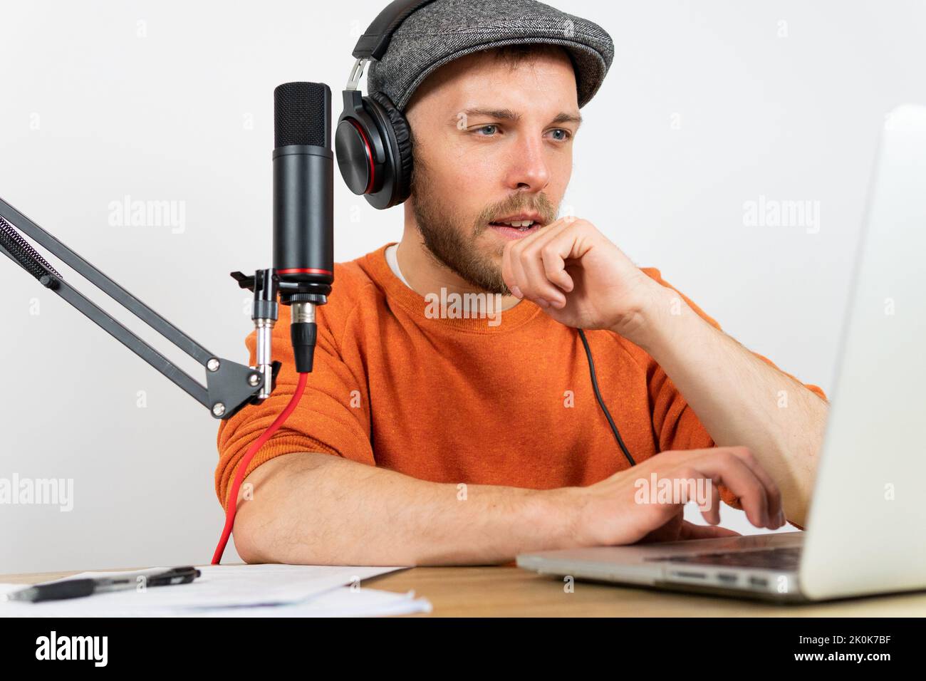 Concentrated male worker with headphones listening to audio while ...