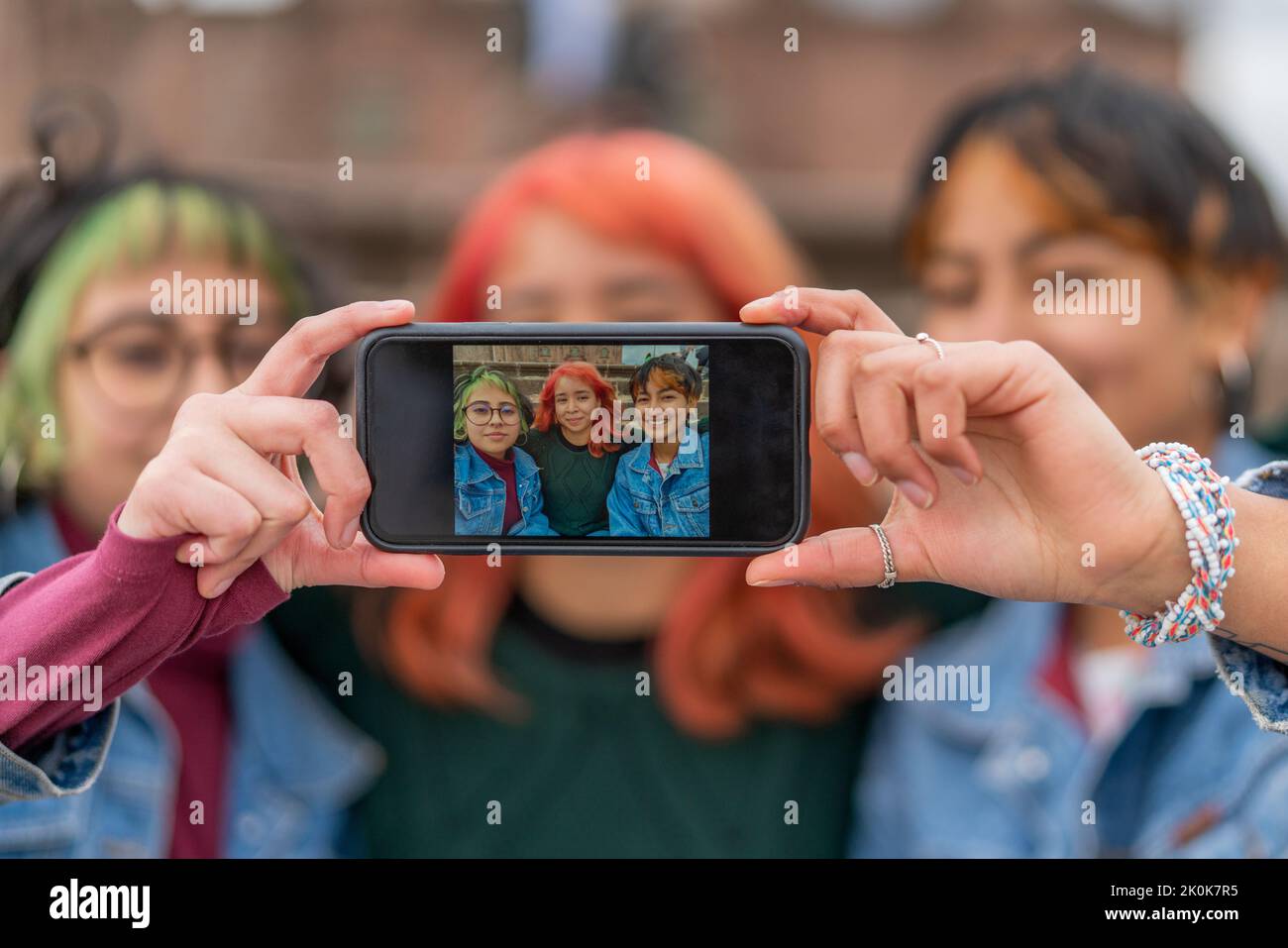 Blurred multiracial female friends taking selfie photo on mobile phone ...