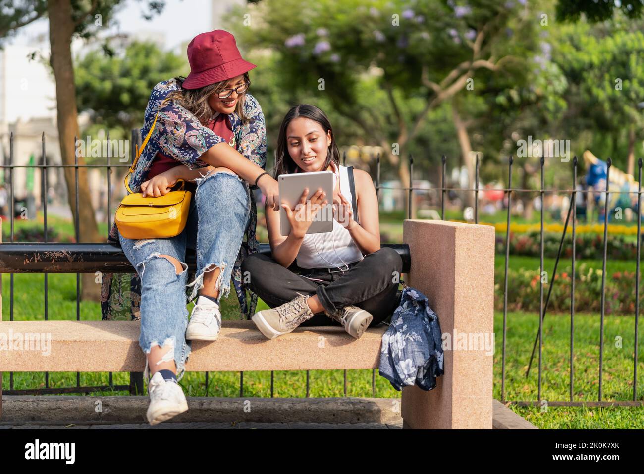 Full body of happy Peruvian female friends in casual wear surfing ...