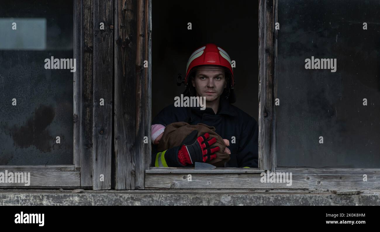 Firefighter hero carrying baby girl out from burning building area from ...