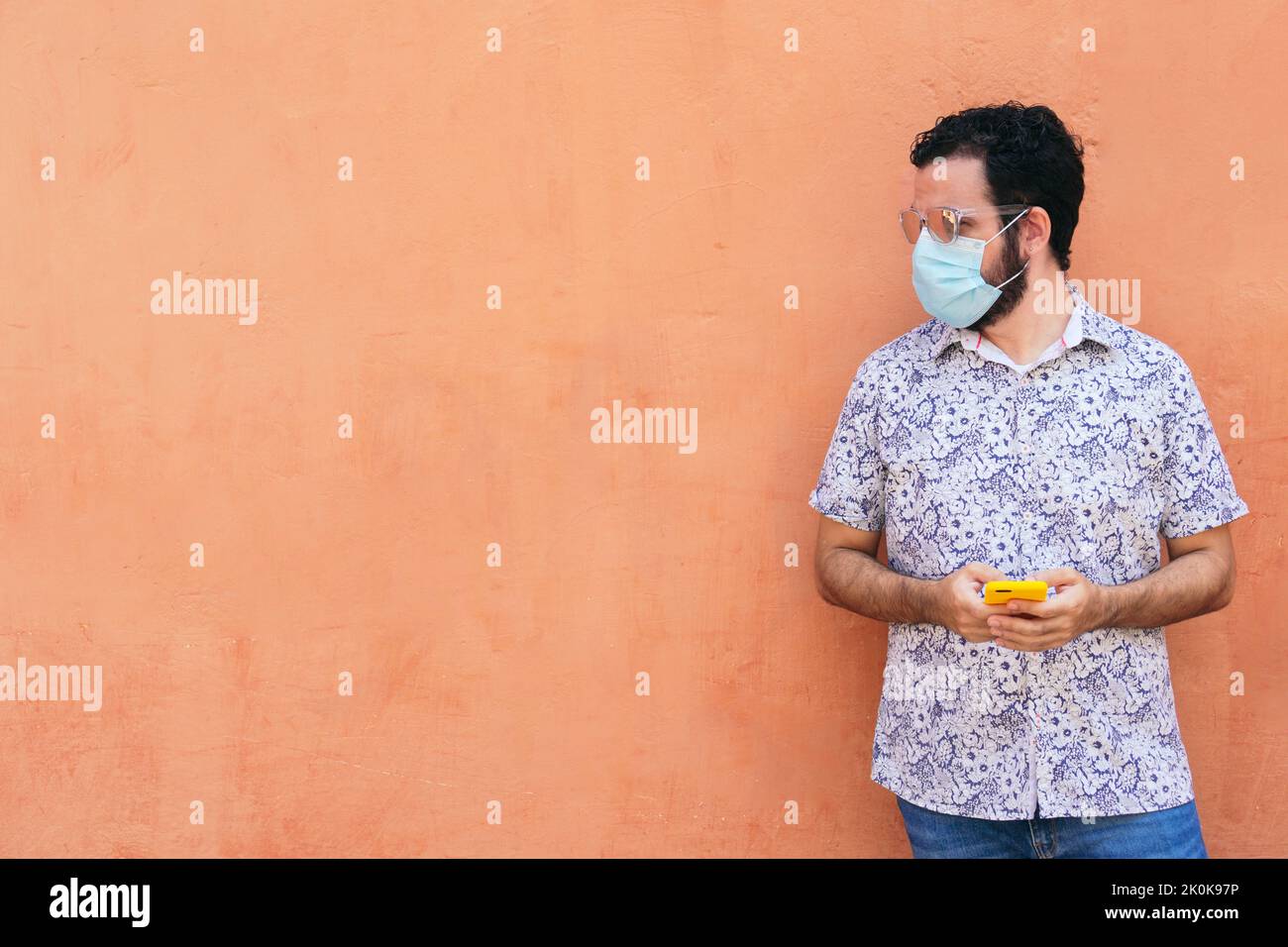 Ethnic male wearing medical mask during coronavirus surfing Internet on ...