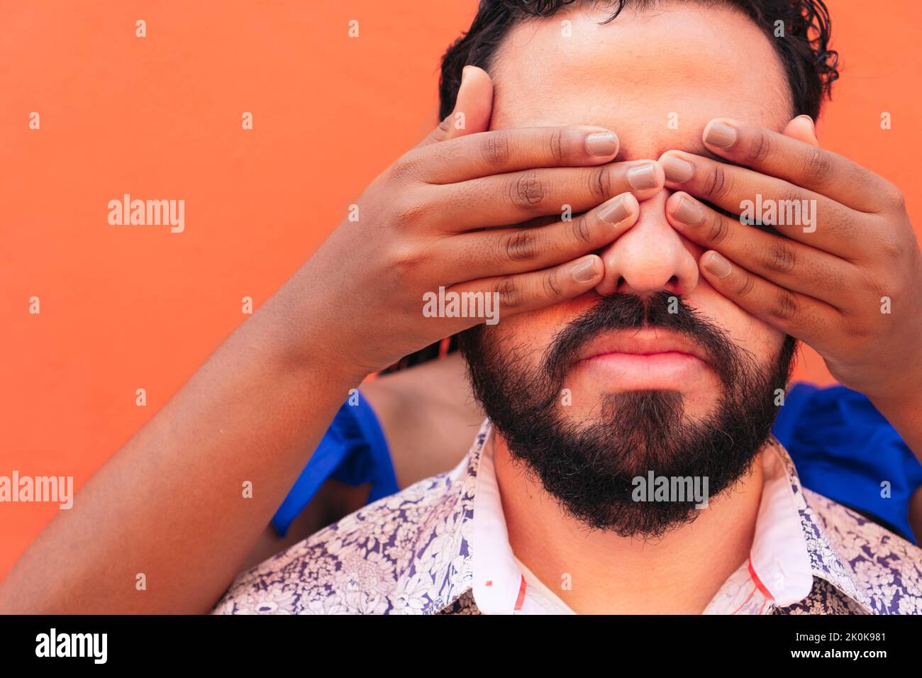 Crop faceless African American female covering eyes of ethnic male on ...