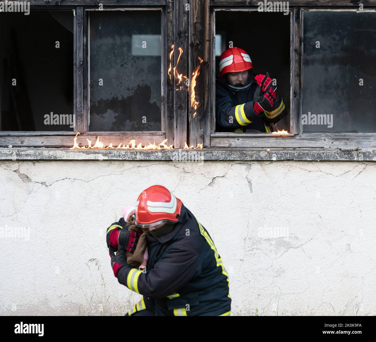 Firefighter hero carrying baby girl out from burning building area from ...