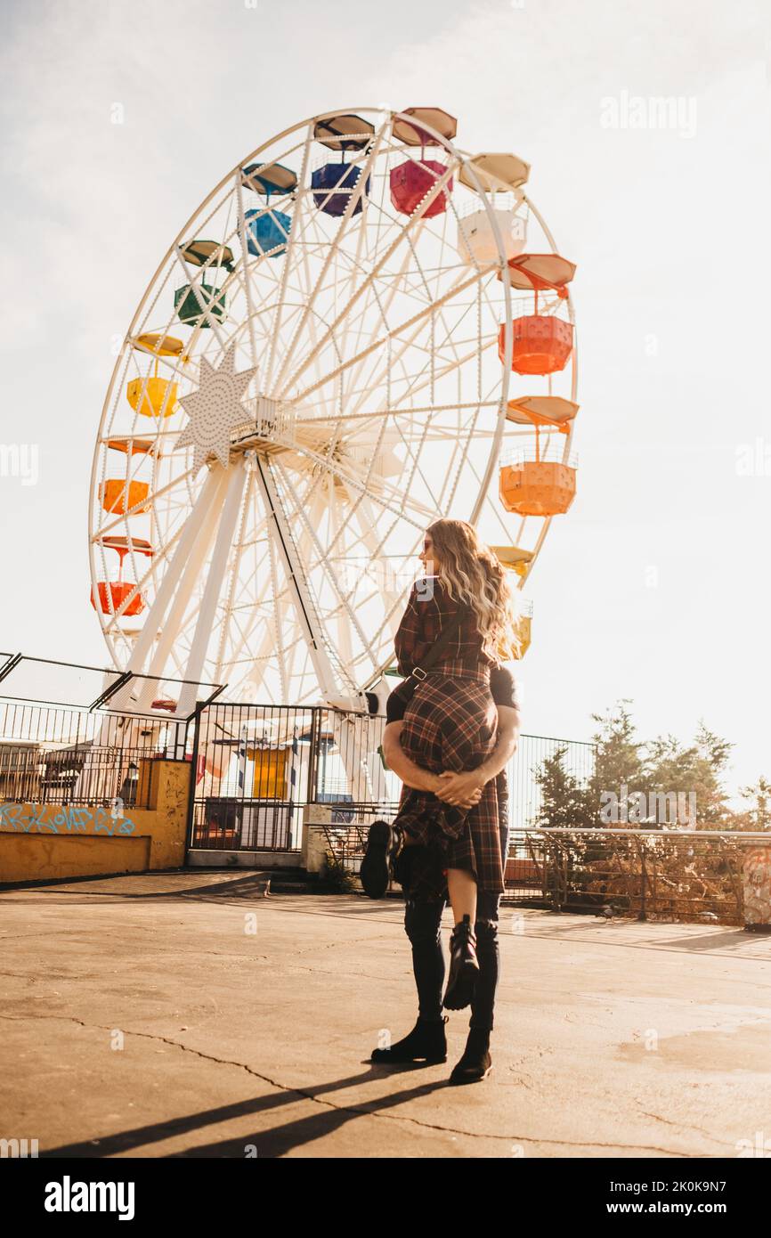 couple giving a piggyback on a date in a funfair in Barcelona, Spain ...