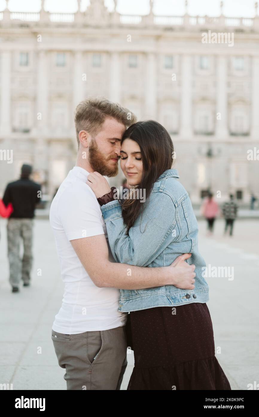Young couple a man and a woman hugging shyly in Puerta del sol Square ...