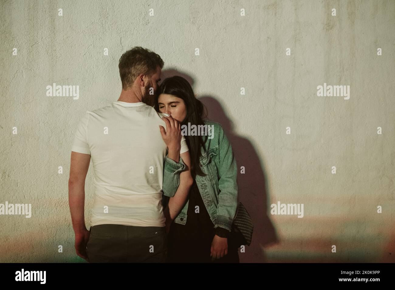 Couple hugging against wall hi-res stock photography and images - Alamy