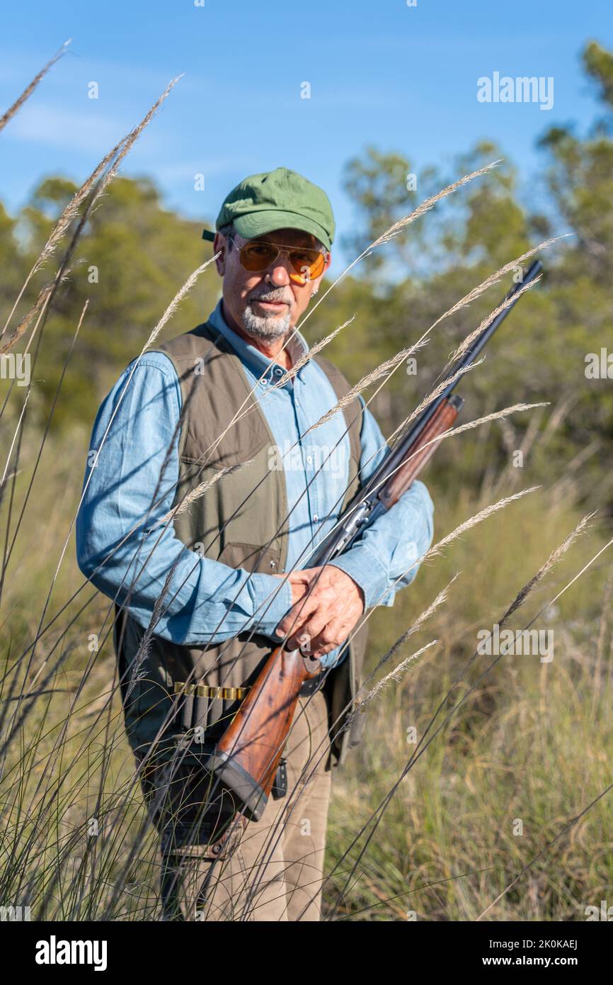 Male hunter in camouflage wear wearing green cap and sunglasses looking ...