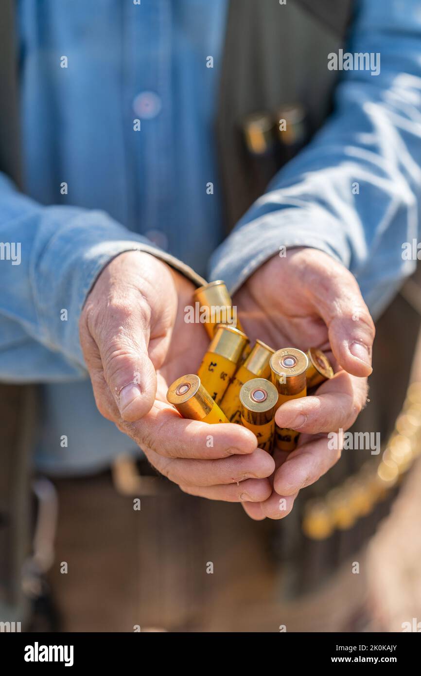 From above of crop hands of male hunter in camouflage wear holding in ...