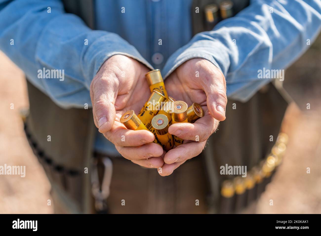 From above of crop hands of male hunter in camouflage wear holding in ...