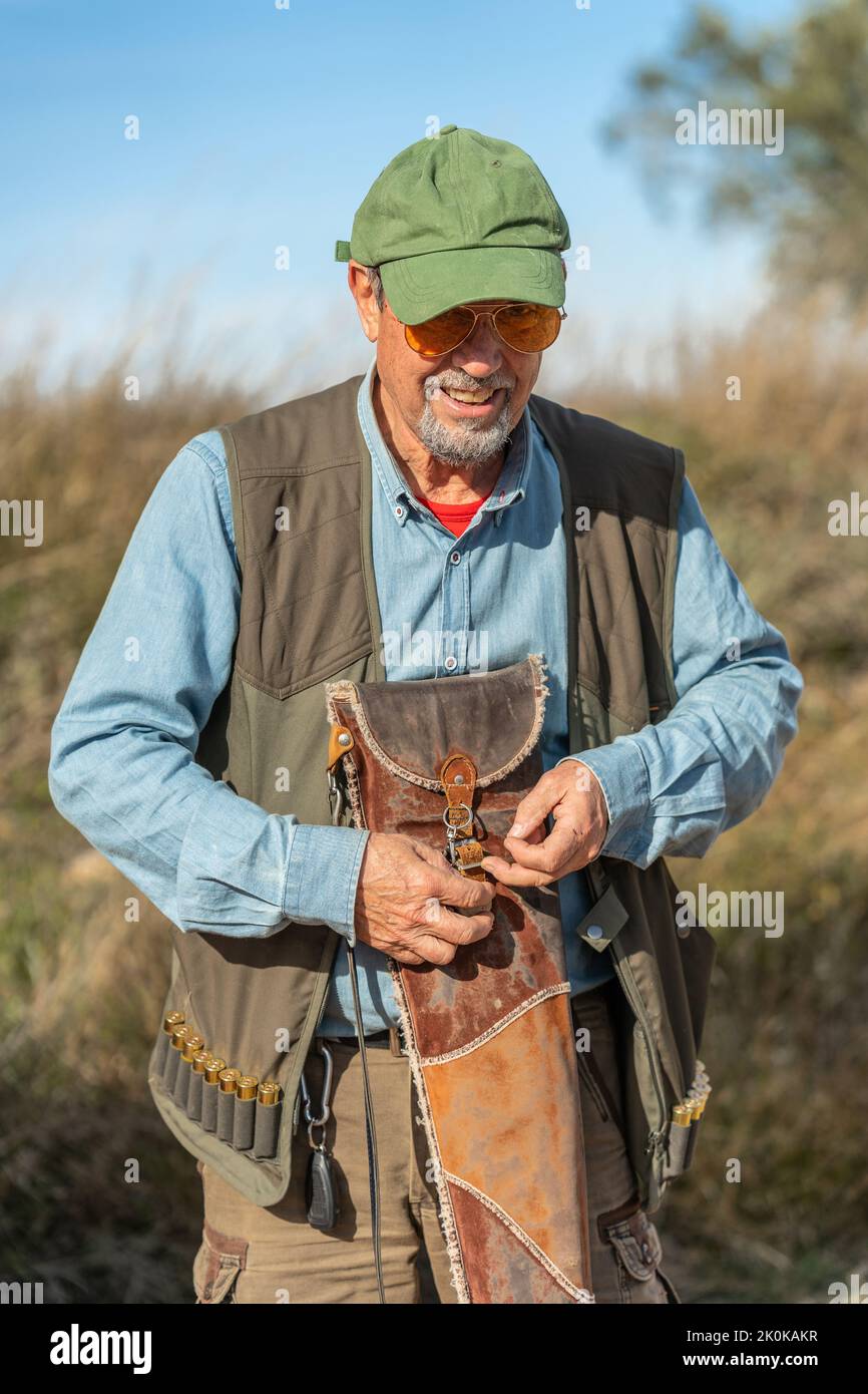 Male hunter in camouflage wear wearing green cap and sunglasses looking ...