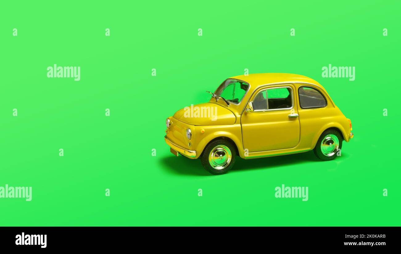 Miniature yellow toy car on green background with copyspace Stock Photo ...