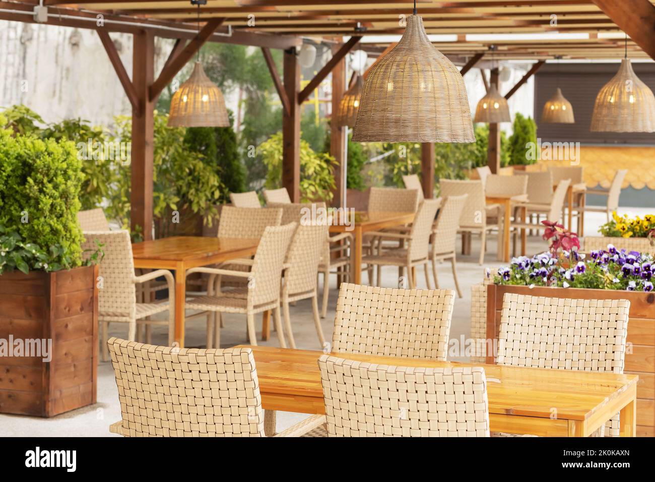 Outdoor cafe with wicker furniture and lamps. Focus on chandelier Stock ...