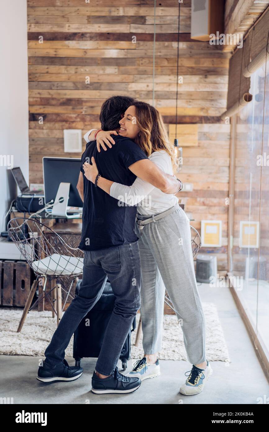 Side view of casual man and female counselor embracing while standing ...
