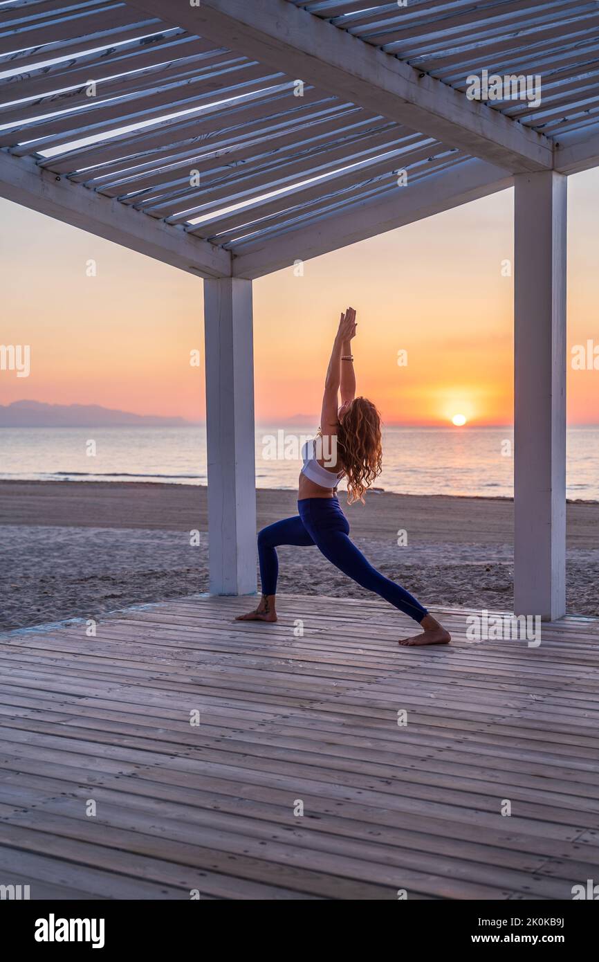 Side view of tranquil female in sportswear practicing yoga in Crescent ...