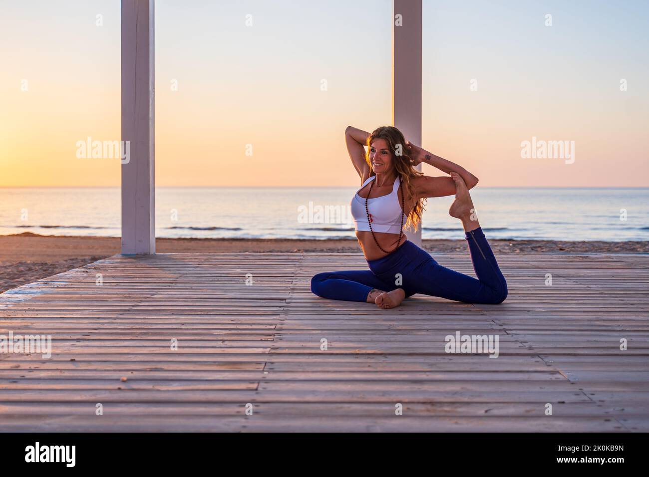 Side view of concentrated female practicing yoga in Mermaid asana while ...