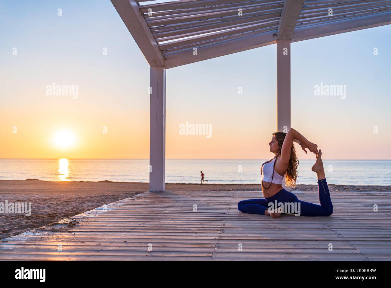 Side view of concentrated female practicing yoga in Mermaid asana while ...