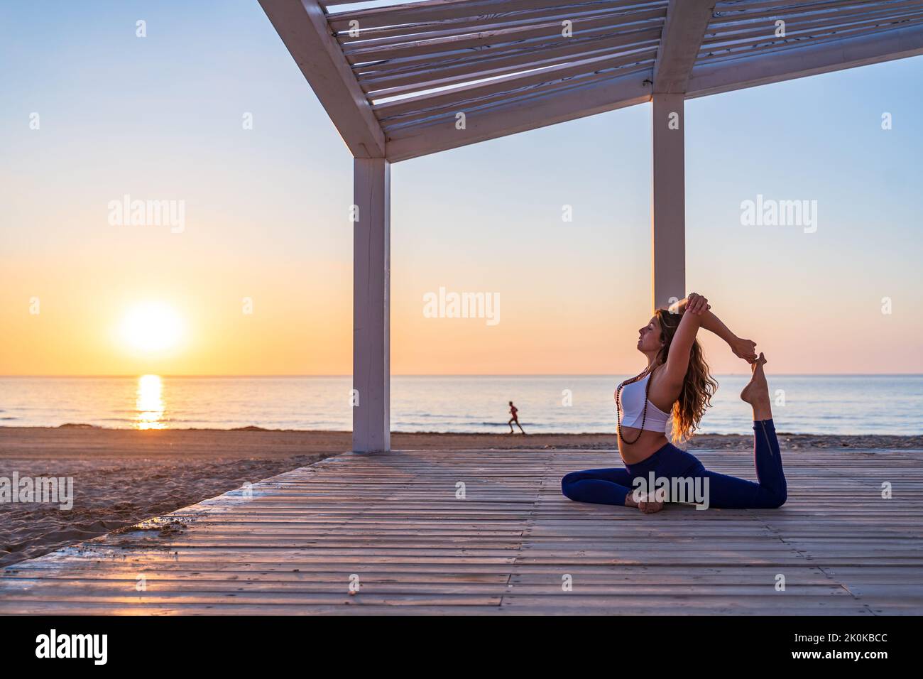 Side view of concentrated female practicing yoga in Mermaid asana while ...